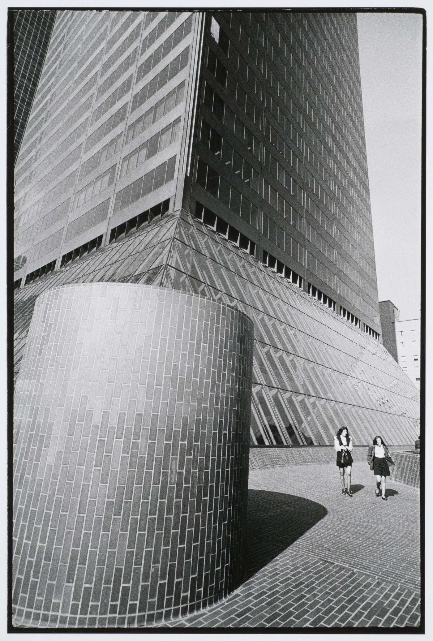 Large oval-shaped building,with women walking