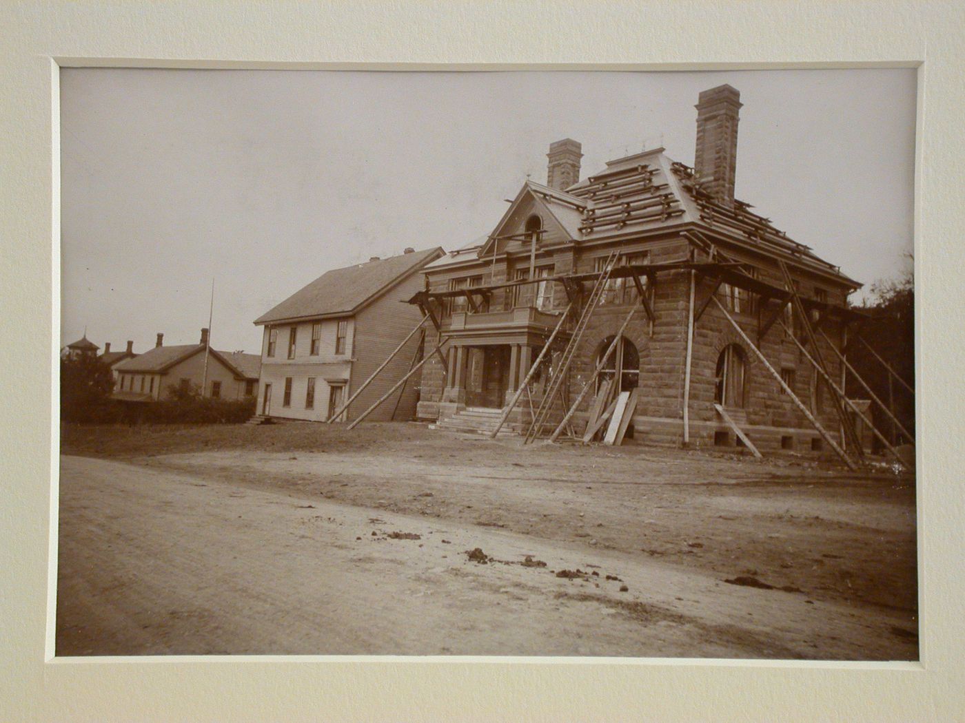 Front view of stone and wood house with scaffolding up to roof
